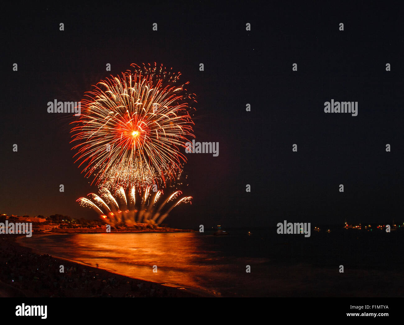 Fireworks display over sea with reflections on the beach Stock Photo ...