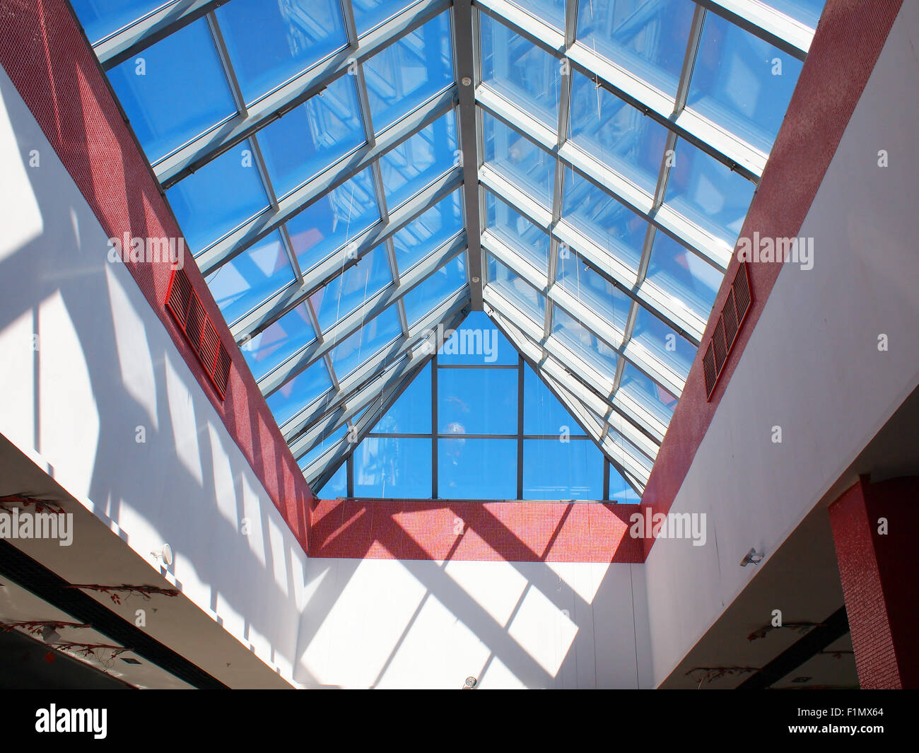 Bottom view on the triangular glass roof of an office building. Through ...