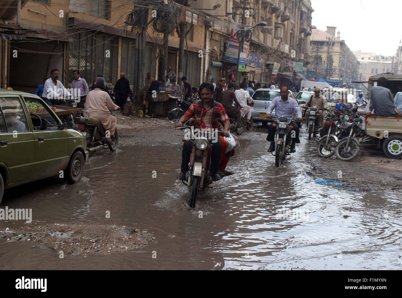 Commuters passing through the devastated road by sewage and sewerage ...