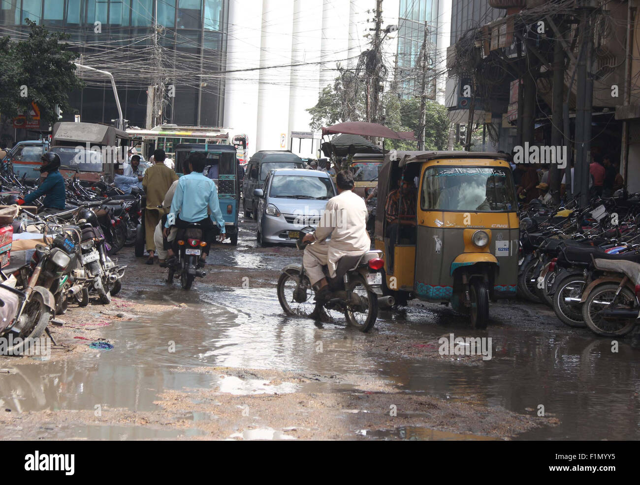 Commuters passing through the devastated road by sewage and sewerage ...