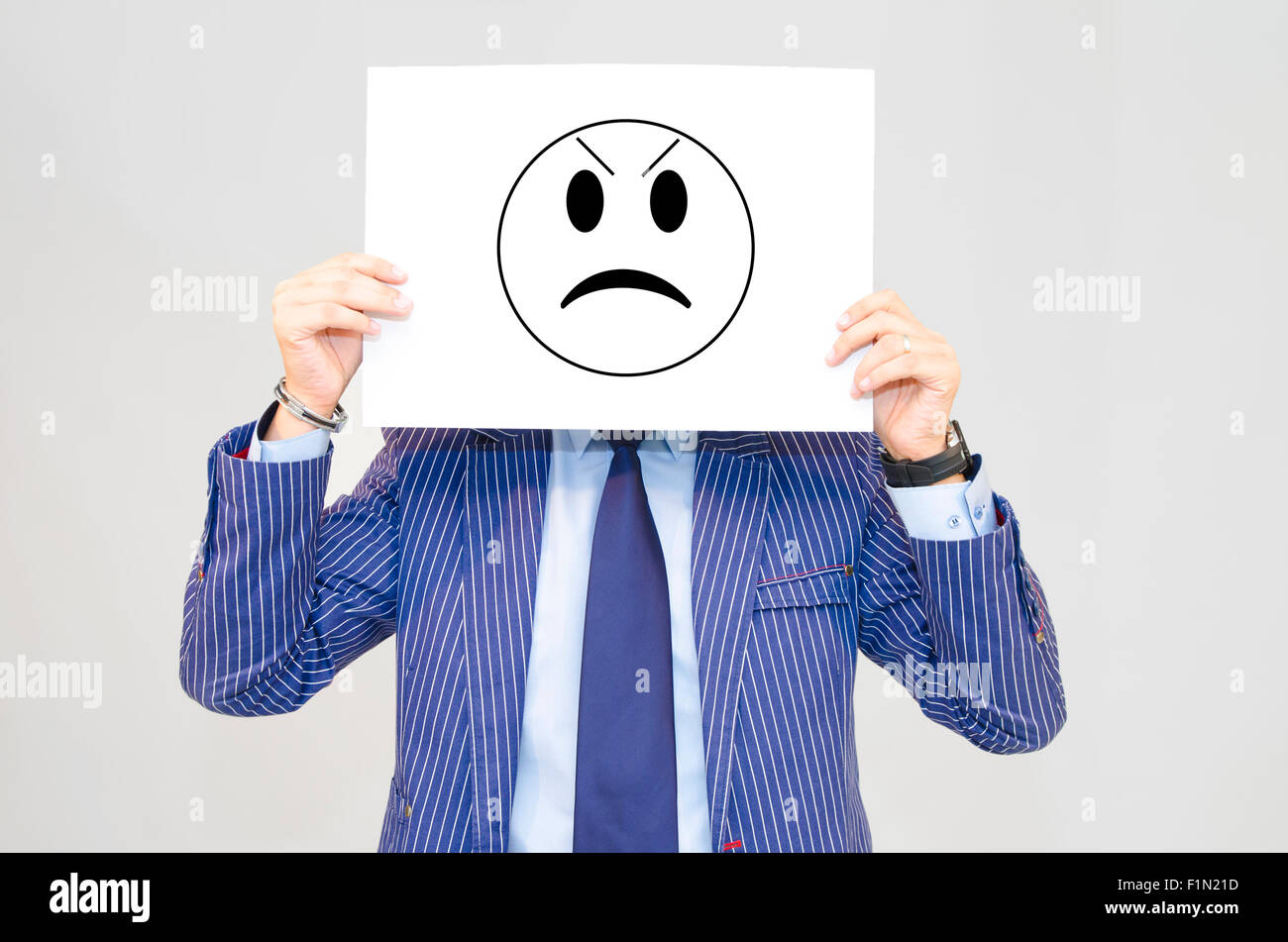 Business man hoding card with angry face isolated on grey background ...