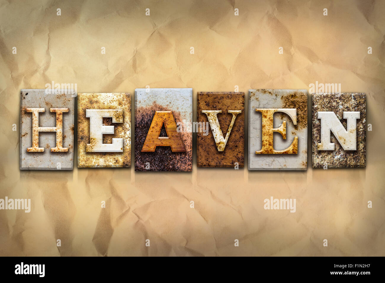 The word "HEAVEN" written in rusty metal letterpress type on a crumbled ...