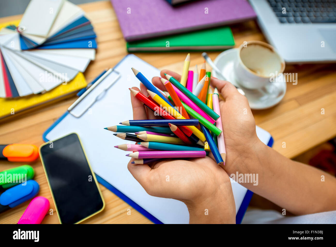 Holding colorful pencils Stock Photo - Alamy