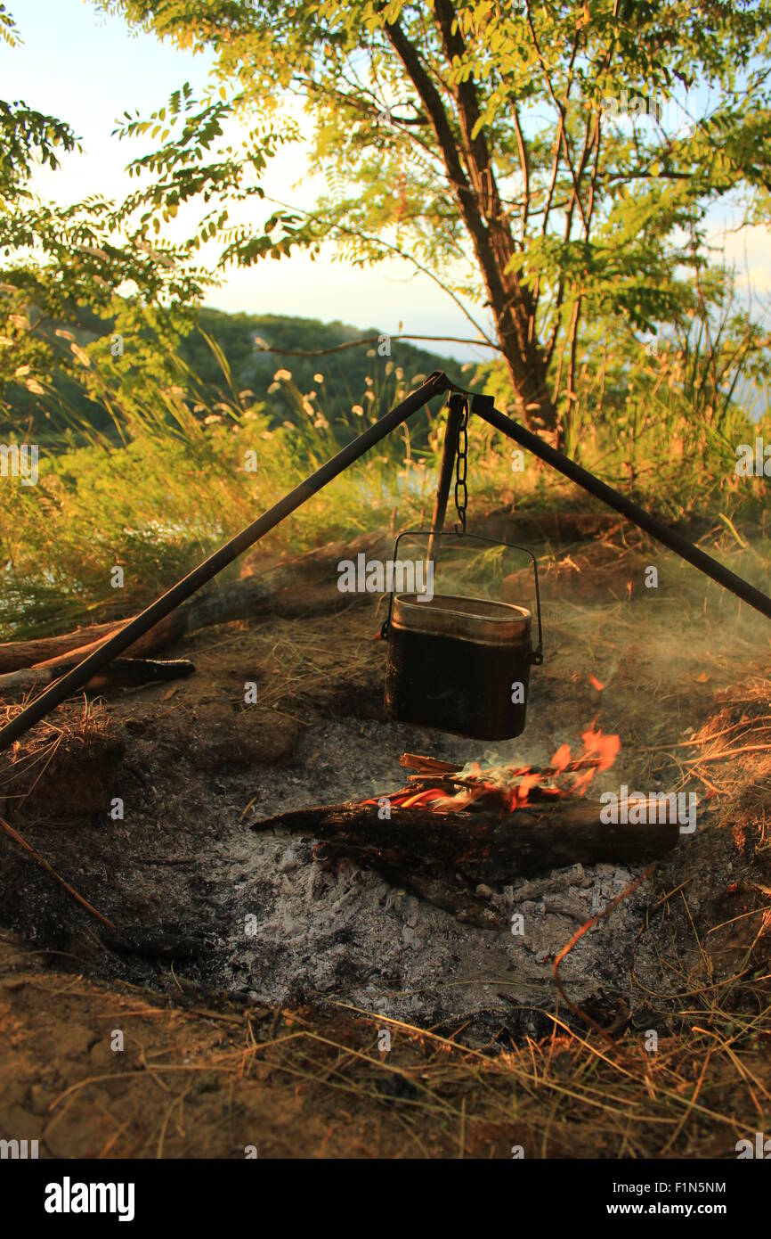 Cooking eat in bowler on the fire in a hike. Summer Stock Photo - Alamy