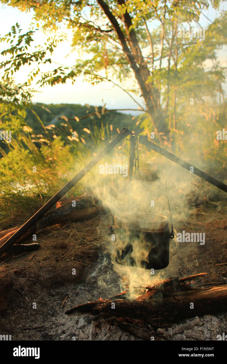 Cooking eat in bowler on the fire in a hike. Summer Stock Photo - Alamy