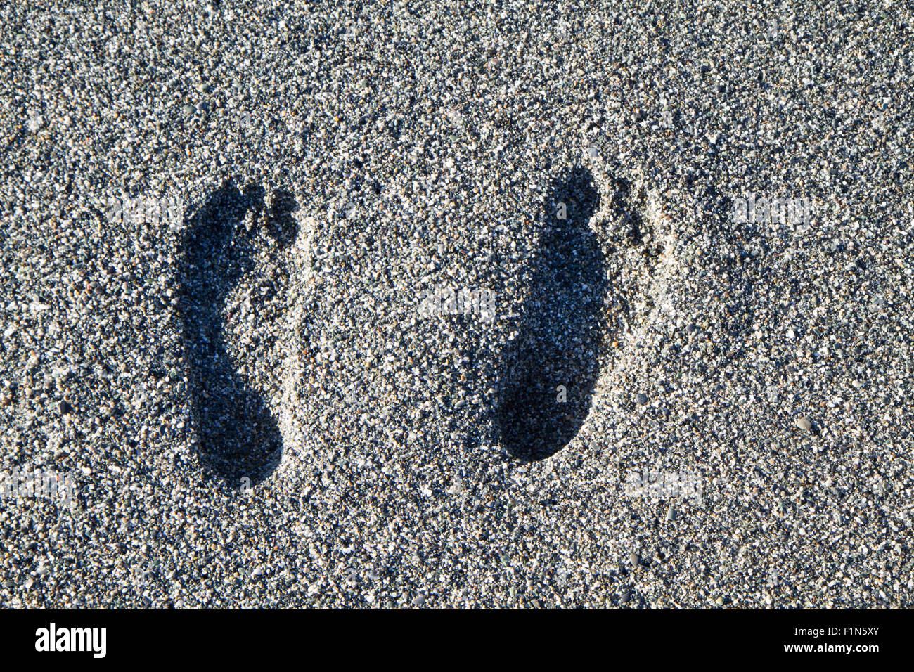 backgroun footprints on the beach of gray stones Stock Photo - Alamy