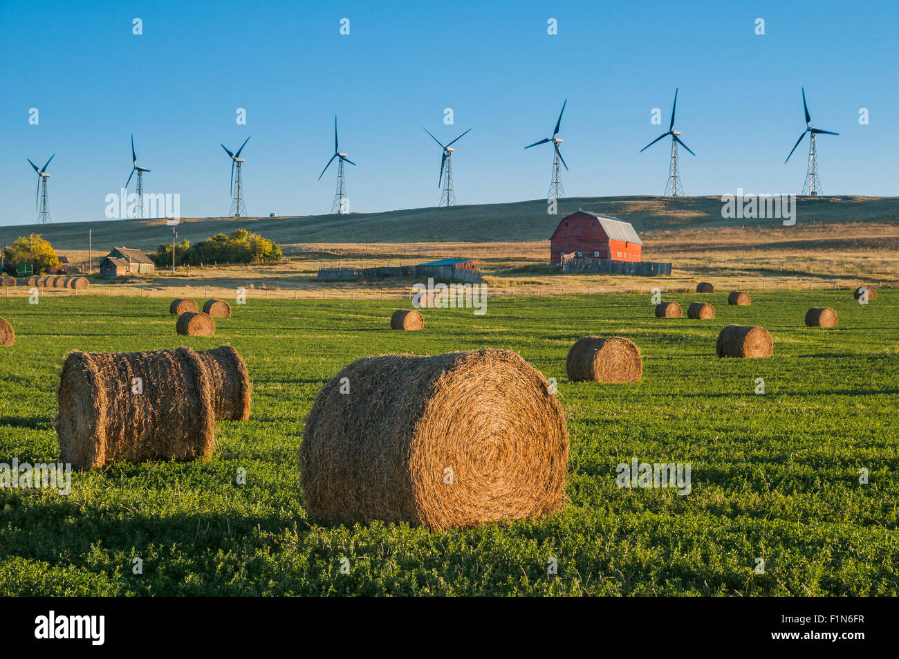 Hay bales and farm, with Cowley Ridge wind plant generator turbines in ...