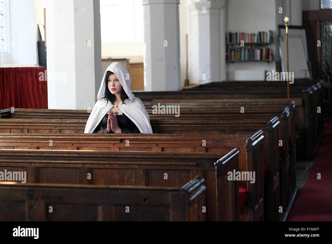 Young pretty goth girl alone in a church pew Stock Photo - Alamy