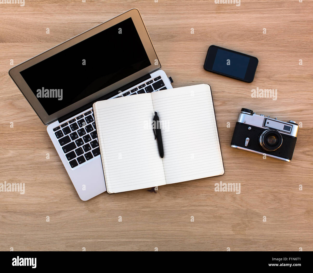 Open Notepad, a laptop, a vintage camera and smartphone, top view laid ...