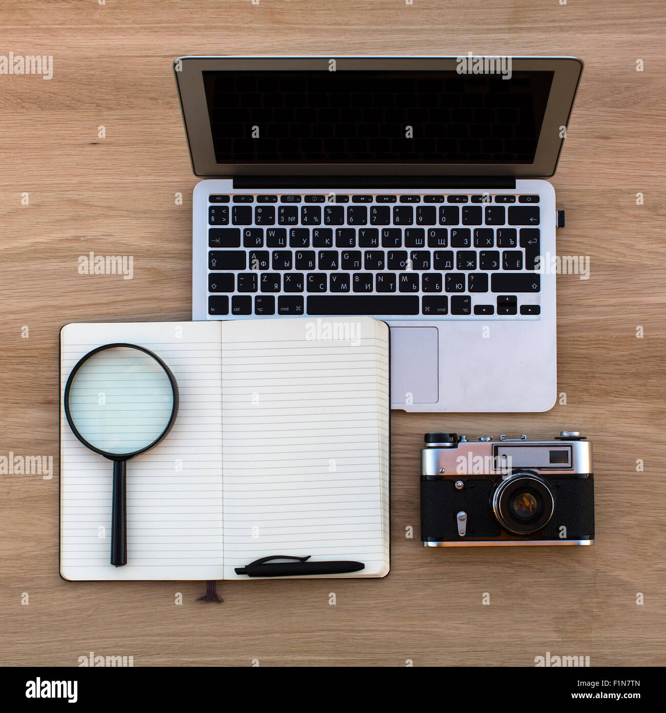 Laptop, Notepad with pen, magnifying glass and vintage camera, top view ...