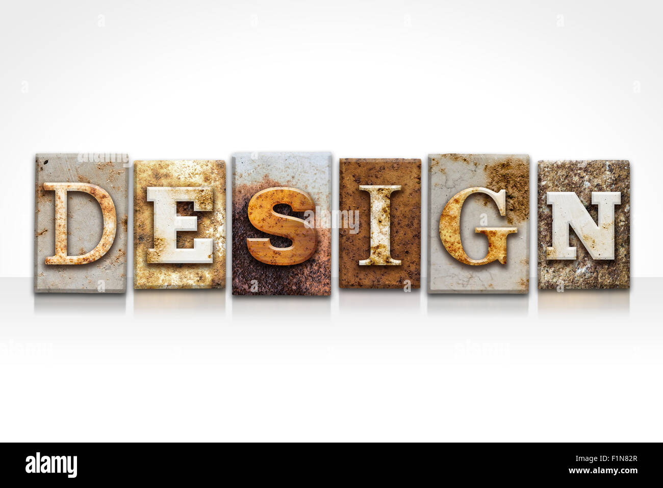 The word "DESIGN" written in rusty metal letterpress type isolated on a ...
