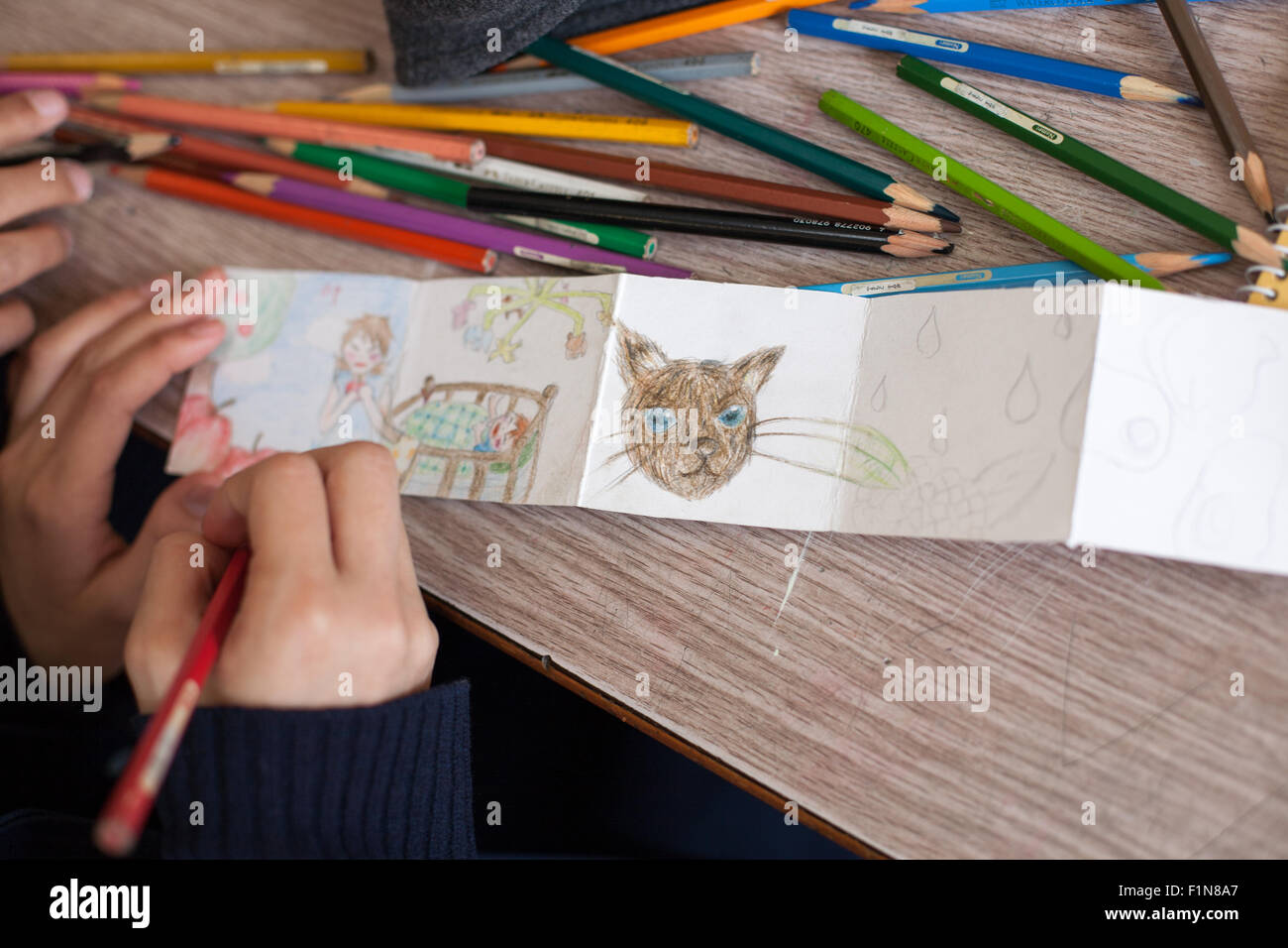 Girls hand drawing with color pencil on a white fold out card Stock ...