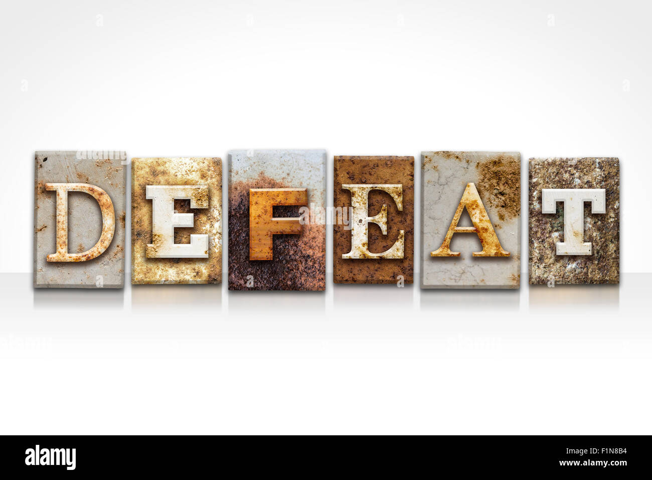 The word "DEFEAT" written in rusty metal letterpress type isolated on a ...