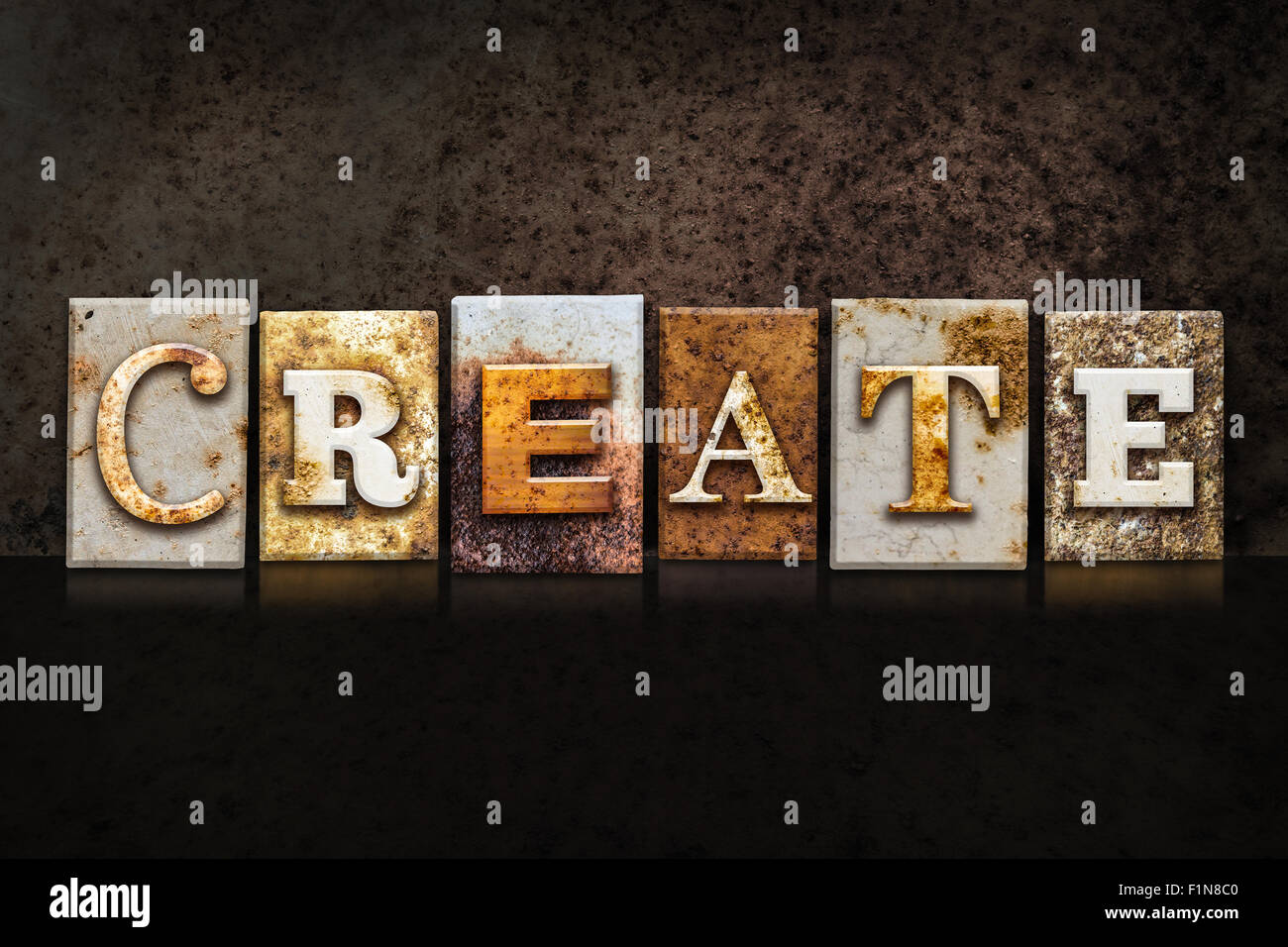The word "CREATE" written in rusty metal letterpress type on a dark ...