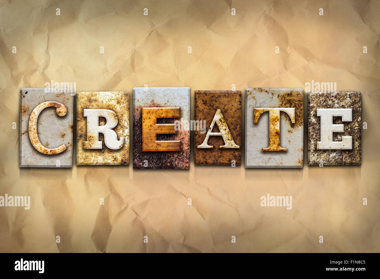 The word "Create" written in rusty metal letterpress type on a crumbled ...