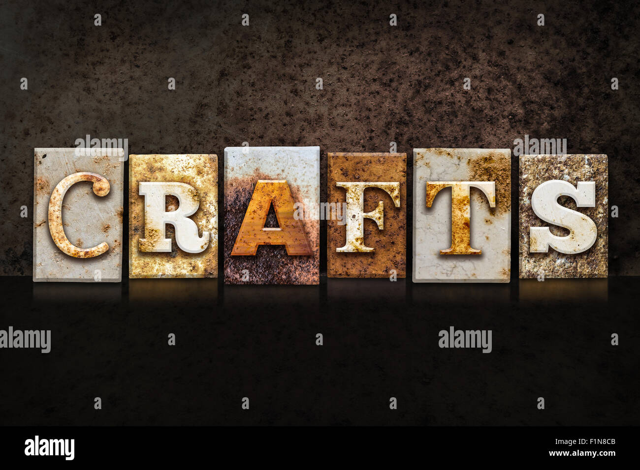 The word "CRAFTS" written in rusty metal letterpress type on a dark ...