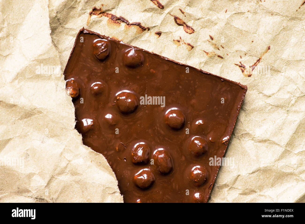 Melted chocolate bar with nuts in paper package Stock Photo - Alamy