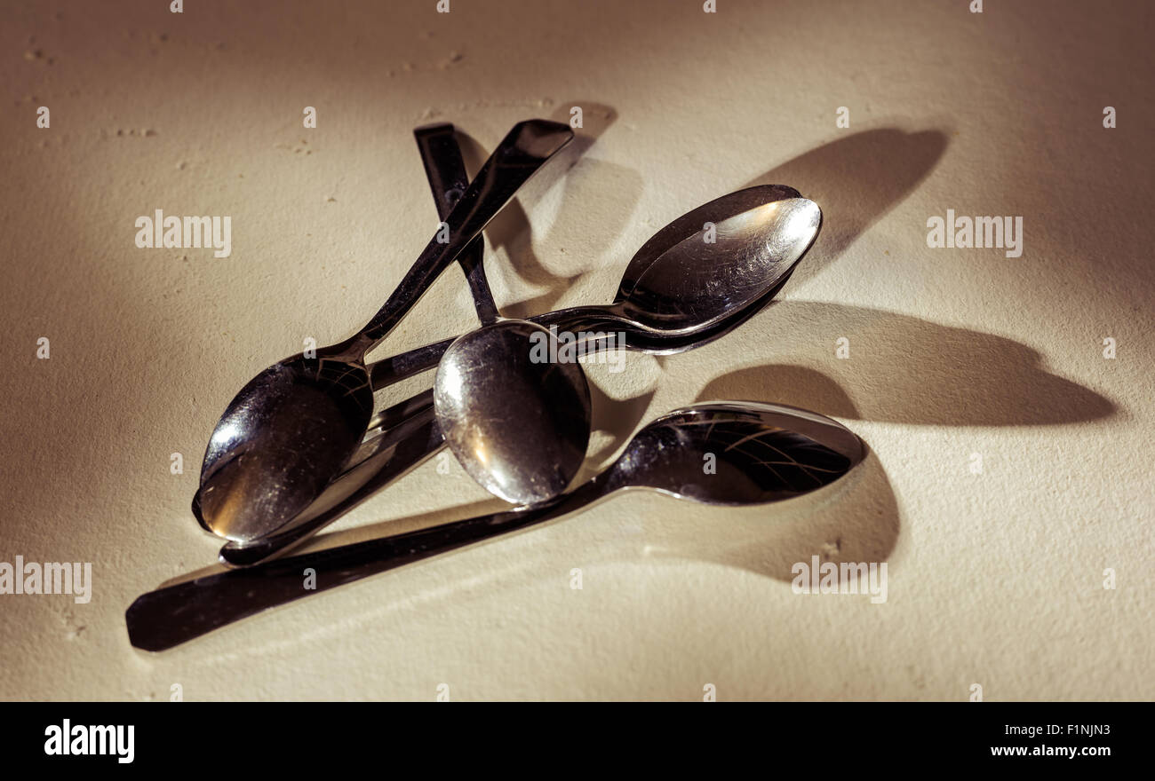 cutlery spoons of steel color cast shadows Stock Photo - Alamy