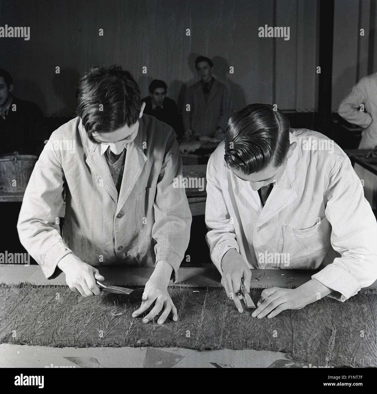 Historical, 1950s, two male trainees or apprentices learning tailoring ...