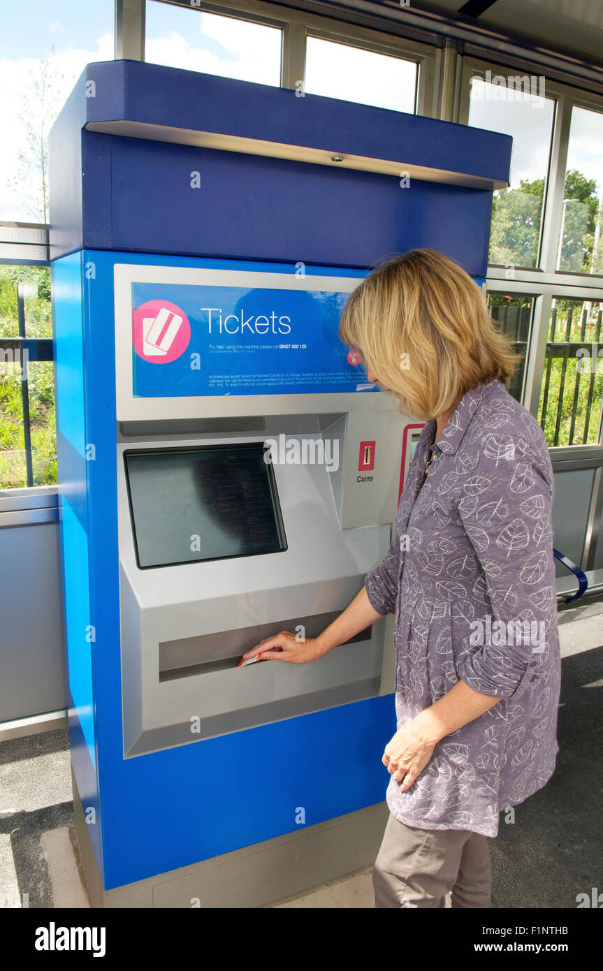 Woman buying rail ticket from a ticket machine at a station, UK Stock ...