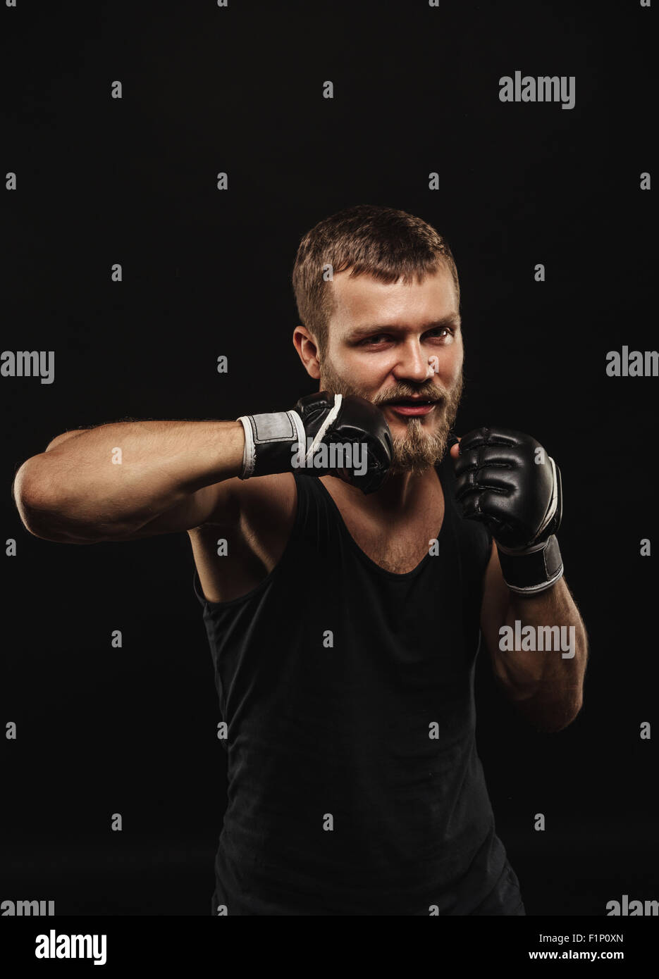 Athletic bearded boxer with gloves on a dark background Stock Photo - Alamy