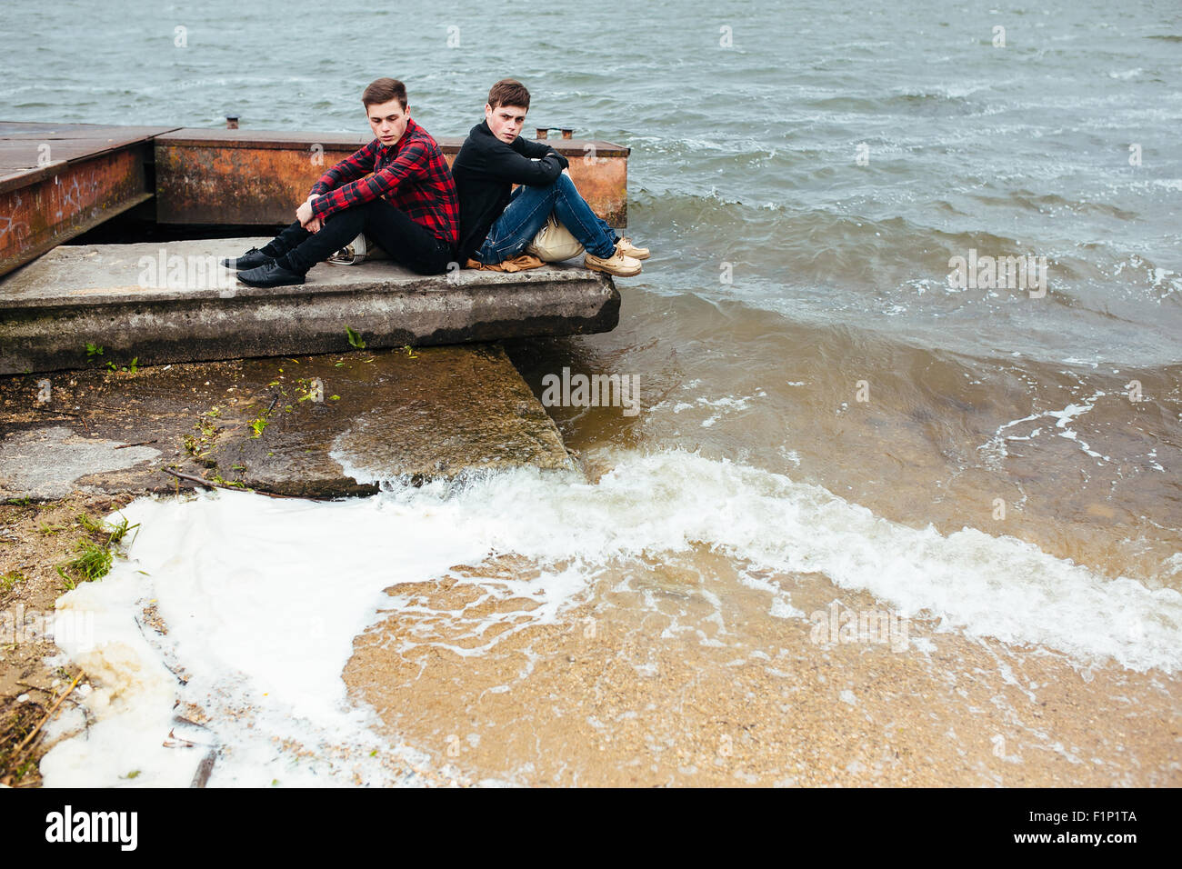 Two friends relaxing on the pier Stock Photo - Alamy