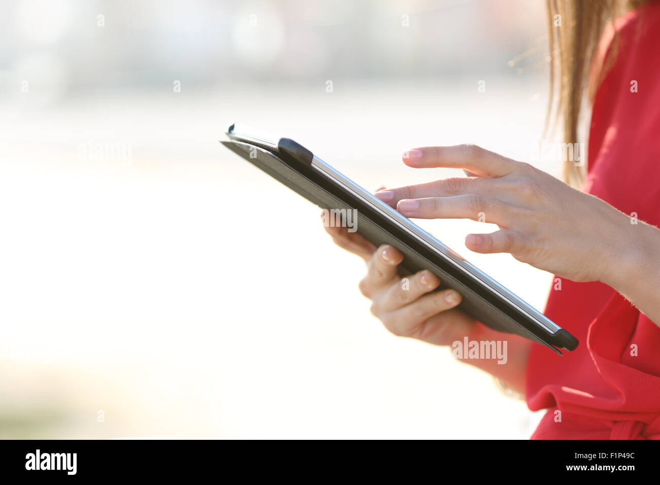 Profile of a woman hands browsing a tablet and touching screen with ...