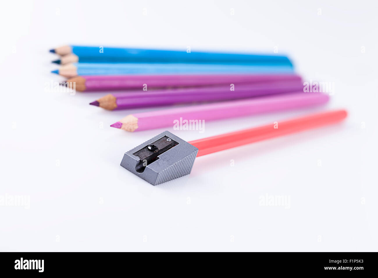 Colored pencils with sharpener on white background Stock Photo - Alamy