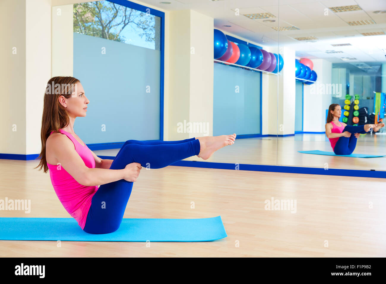 Pilates woman open leg rocker exercise workout at gym indoor Stock ...