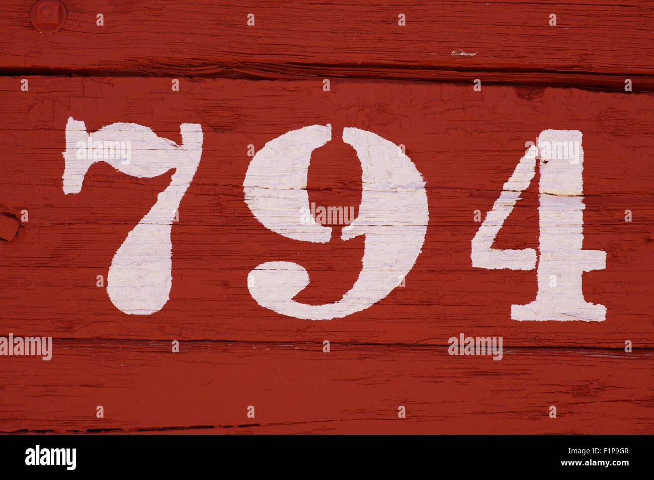 Seven Nine Four - White Paint 794 Number on Red Painted Wood Boards ...