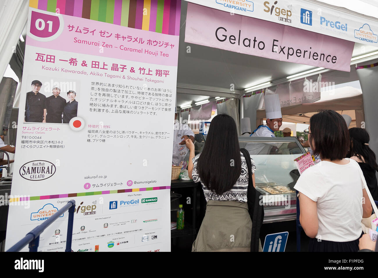 Visitors wait patiently in line to taste various flavours of gelato ice ...