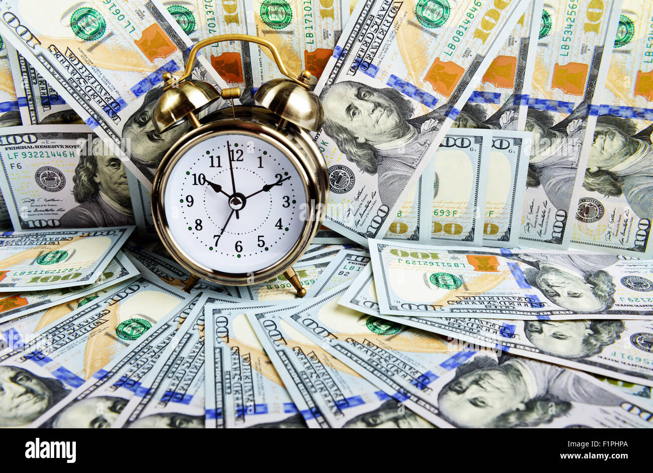 Vintage alarm clock over money Stock Photo - Alamy