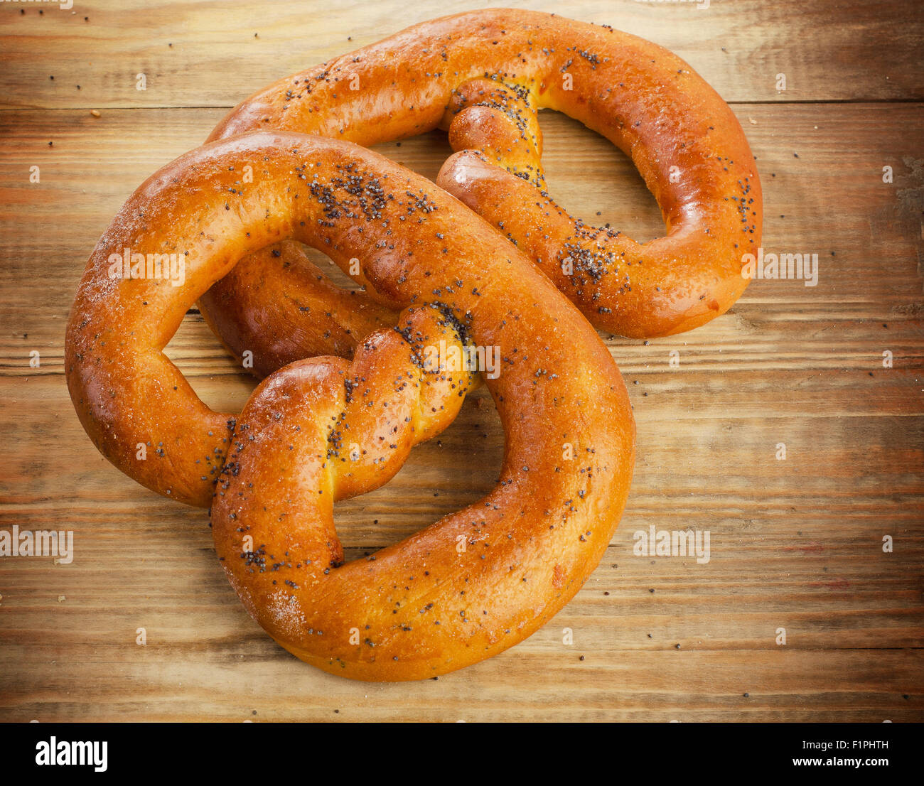 Fresh pretzels on a old wooden board. Top view Stock Photo - Alamy