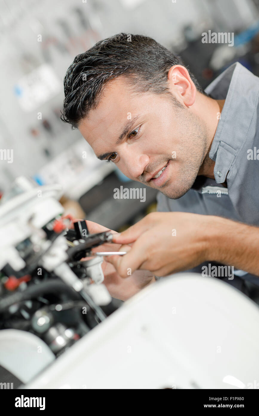 Mechanic examining a scooter Stock Photo - Alamy