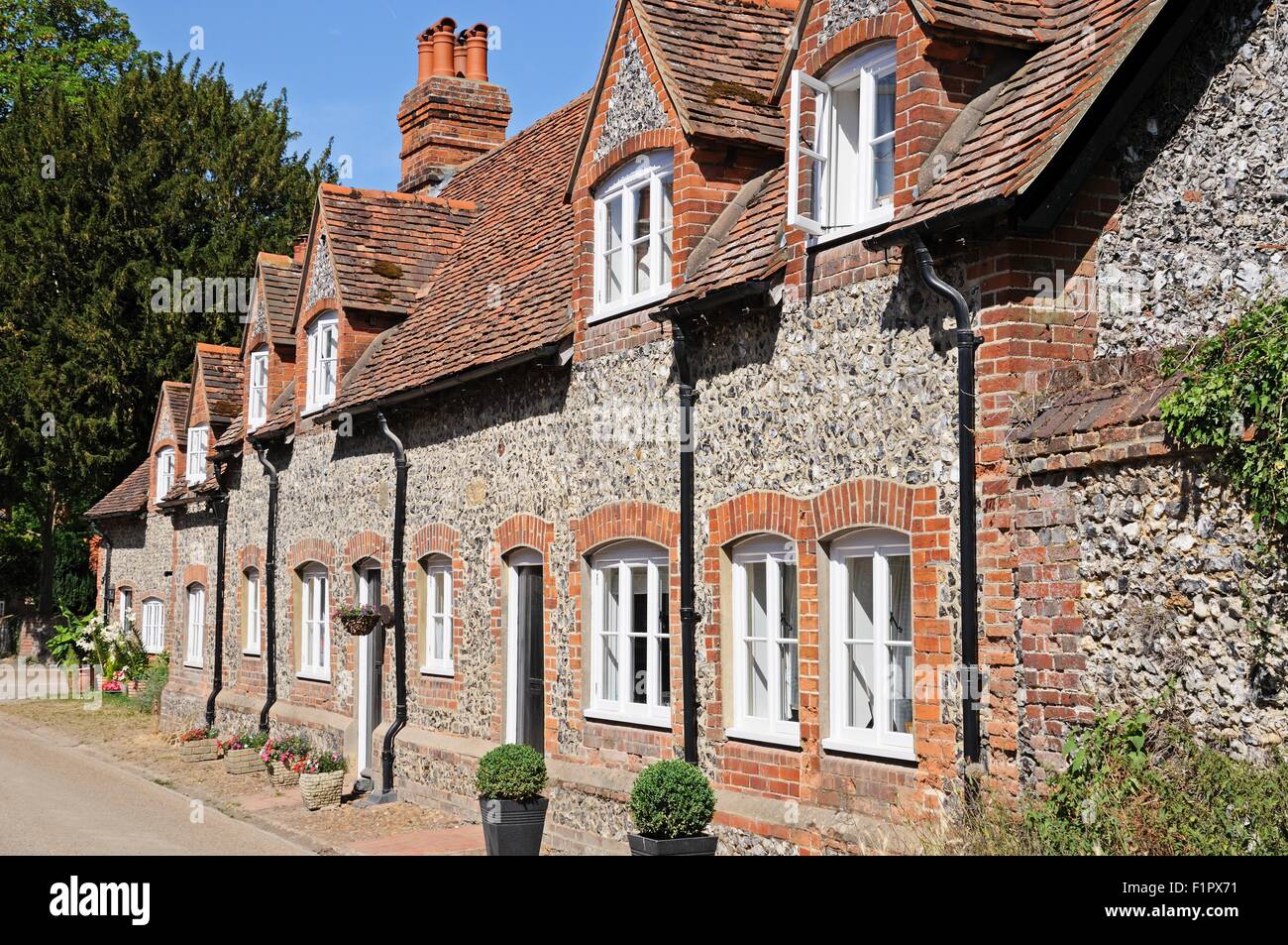 Pretty brick and flint cottages with dormer windows along a village ...