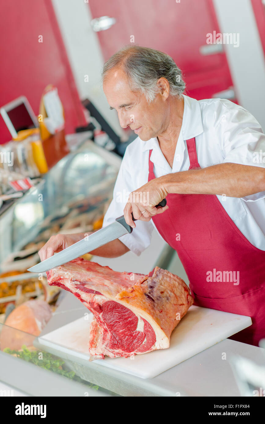 Butcher slicing a big cut of beef Stock Photo - Alamy