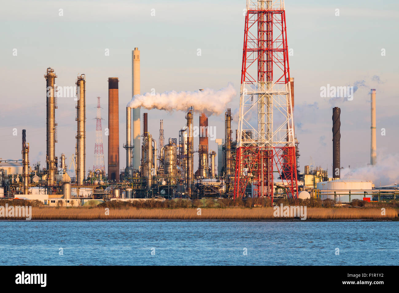 A large oil refinery with flare stack in the port of Antwerp, Belgium ...
