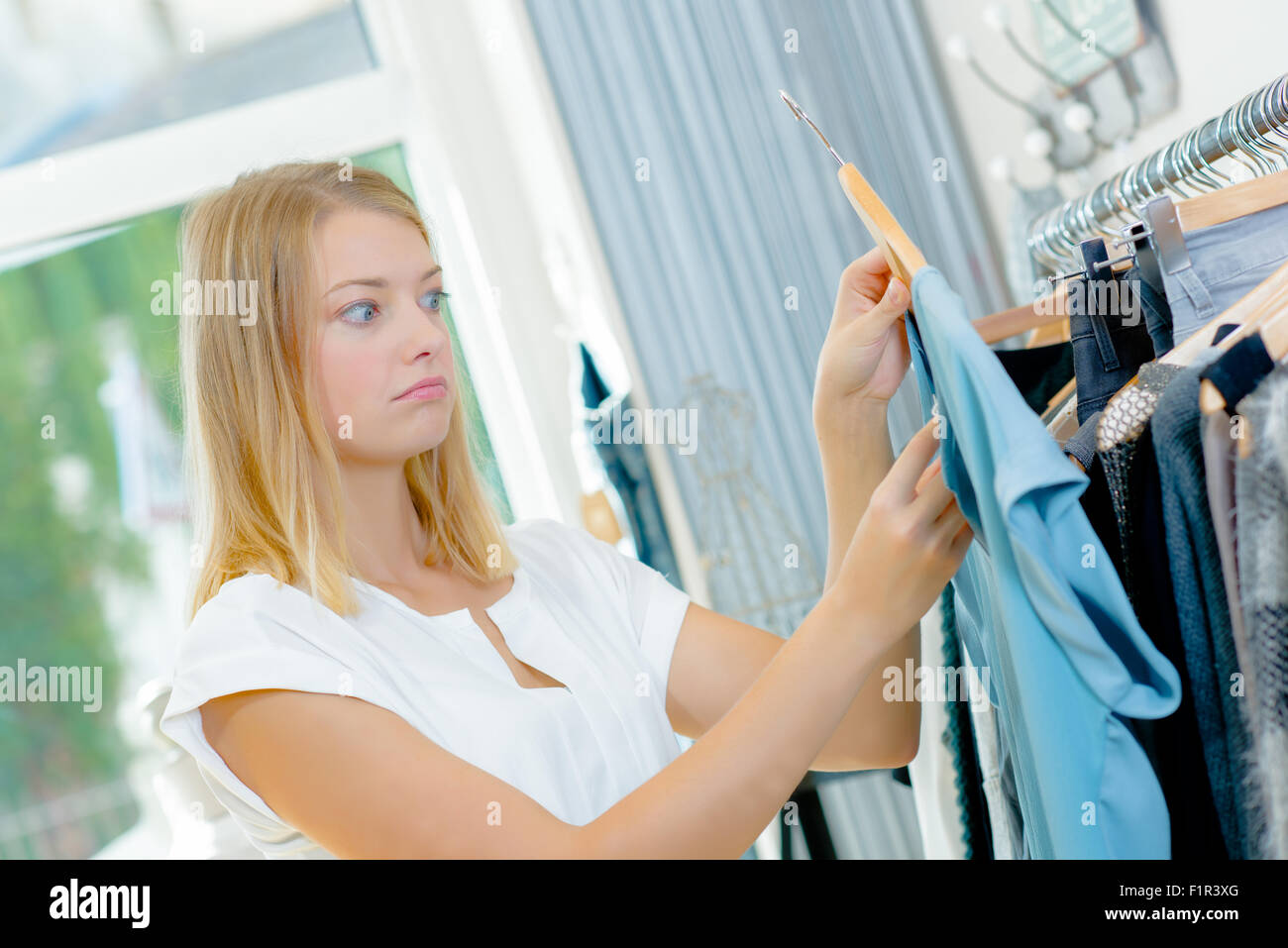 Woman browsing the clothes aisle Stock Photo - Alamy