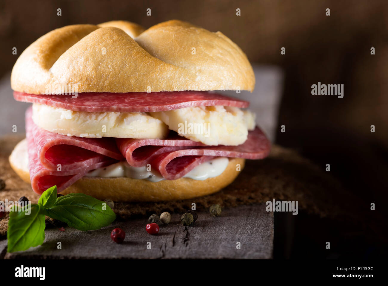 Closeup of a fresh sandwich with salami, cheese and remoulade sauce ...