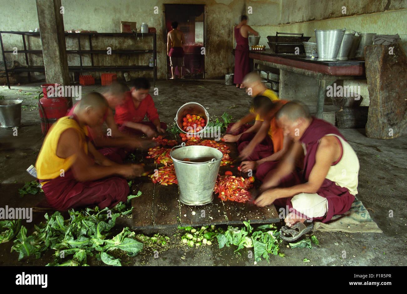 A group of Tibetan monks make lunch in a kitchen for hundreds of other ...