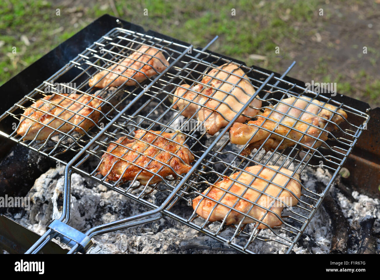 Barbecue chicken over an open fire in summer Stock Photo - Alamy