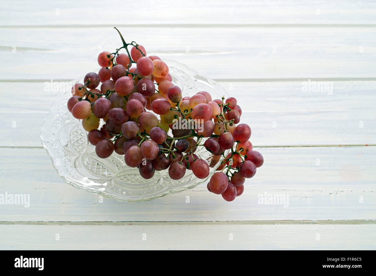 Bunch of grapes on a glass tray on wooden table Stock Photo - Alamy