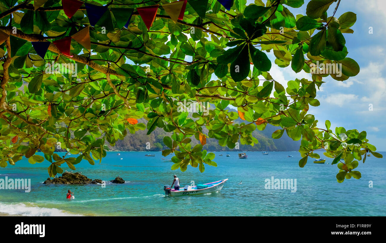 Two fishermen taking their boats and nets out from Little Castara Bay ...
