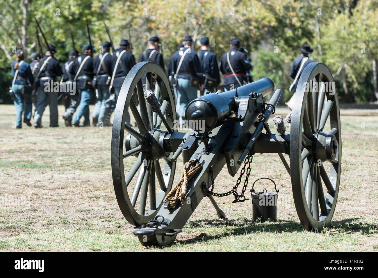 A Civil War era cannon with a group of marching Union soldiers in the ...