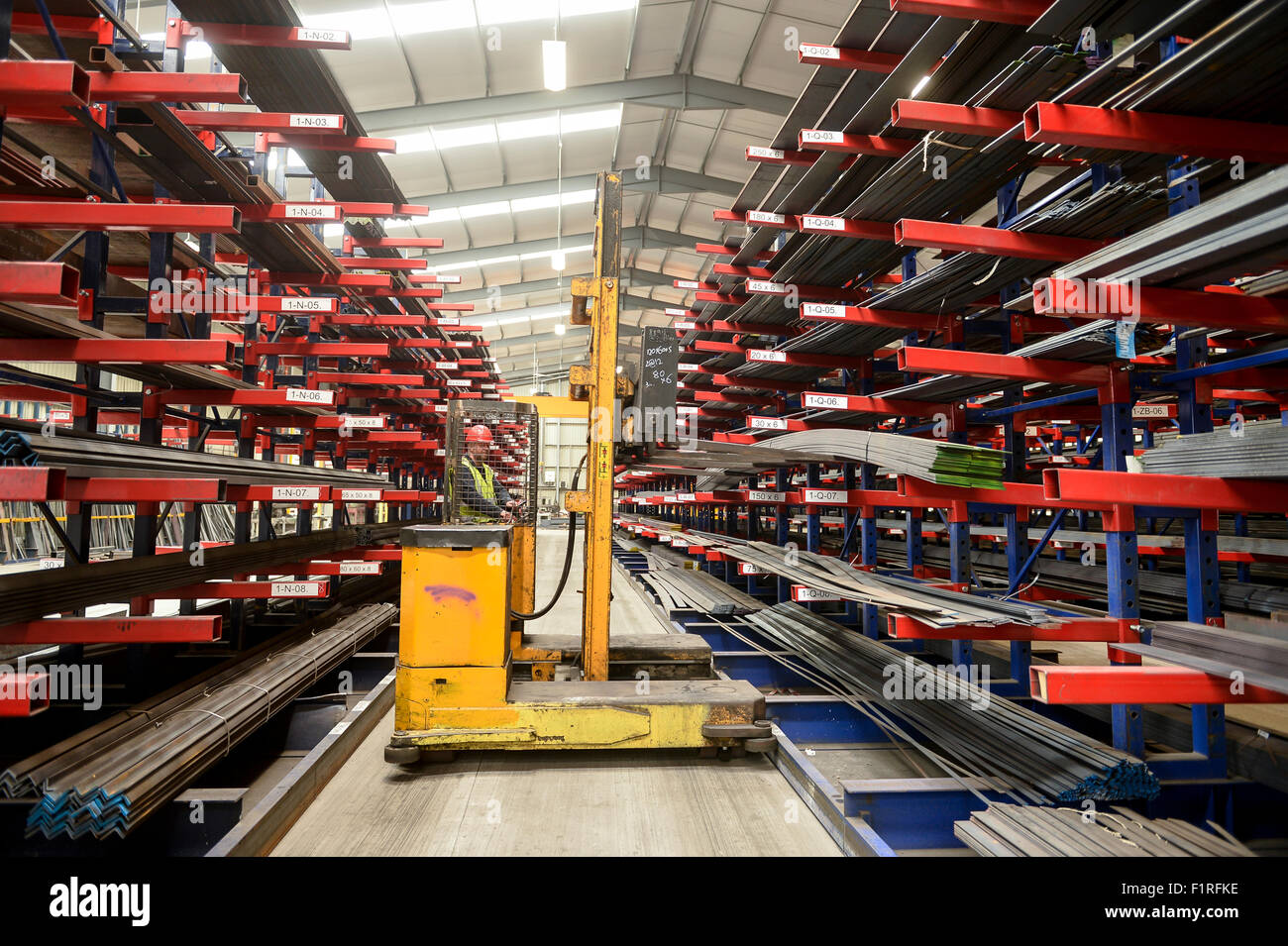 Steel warehouse racking side loading forklift Stock Photo - Alamy