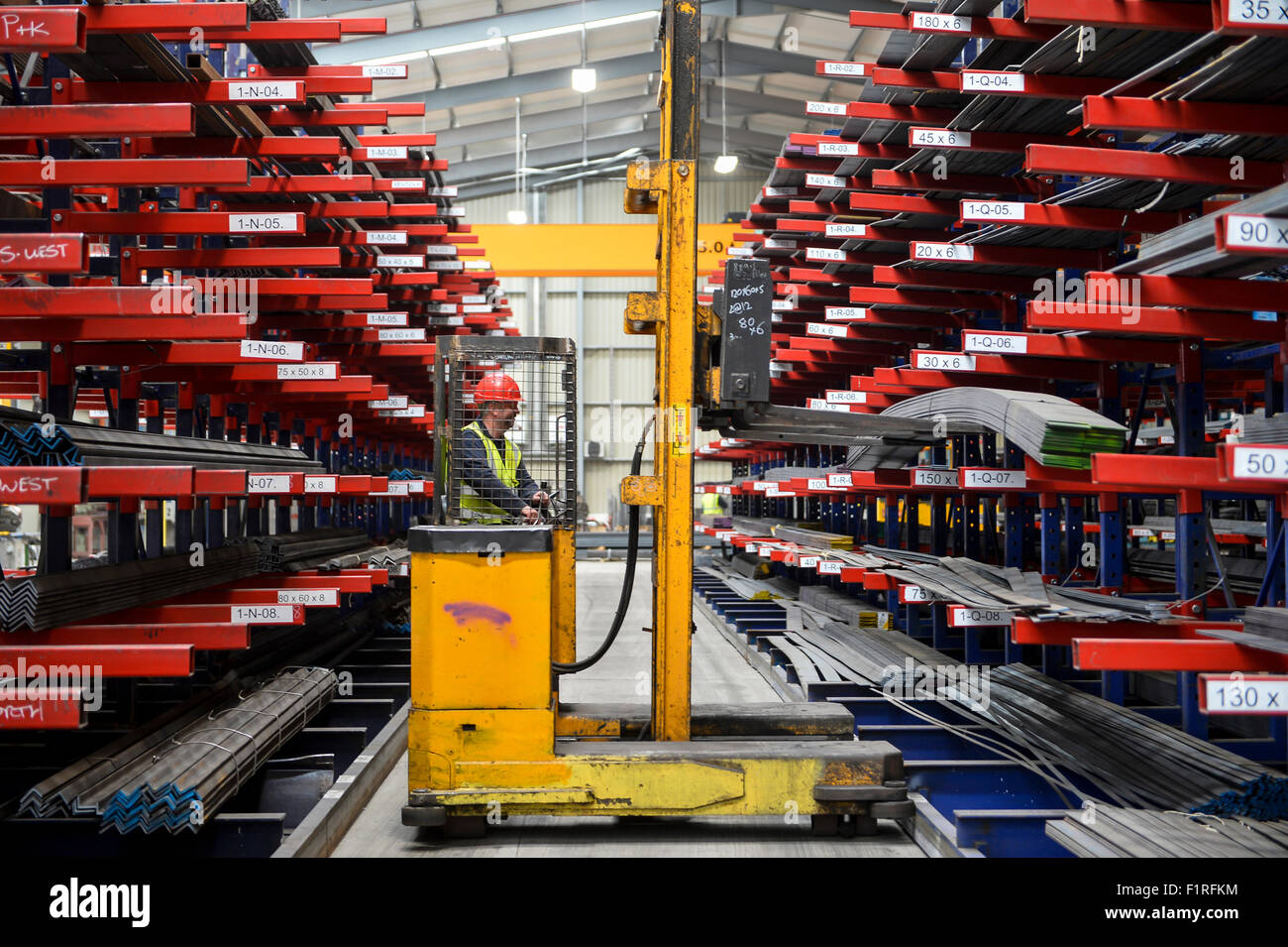 Steel warehouse racking side loading forklift Stock Photo - Alamy