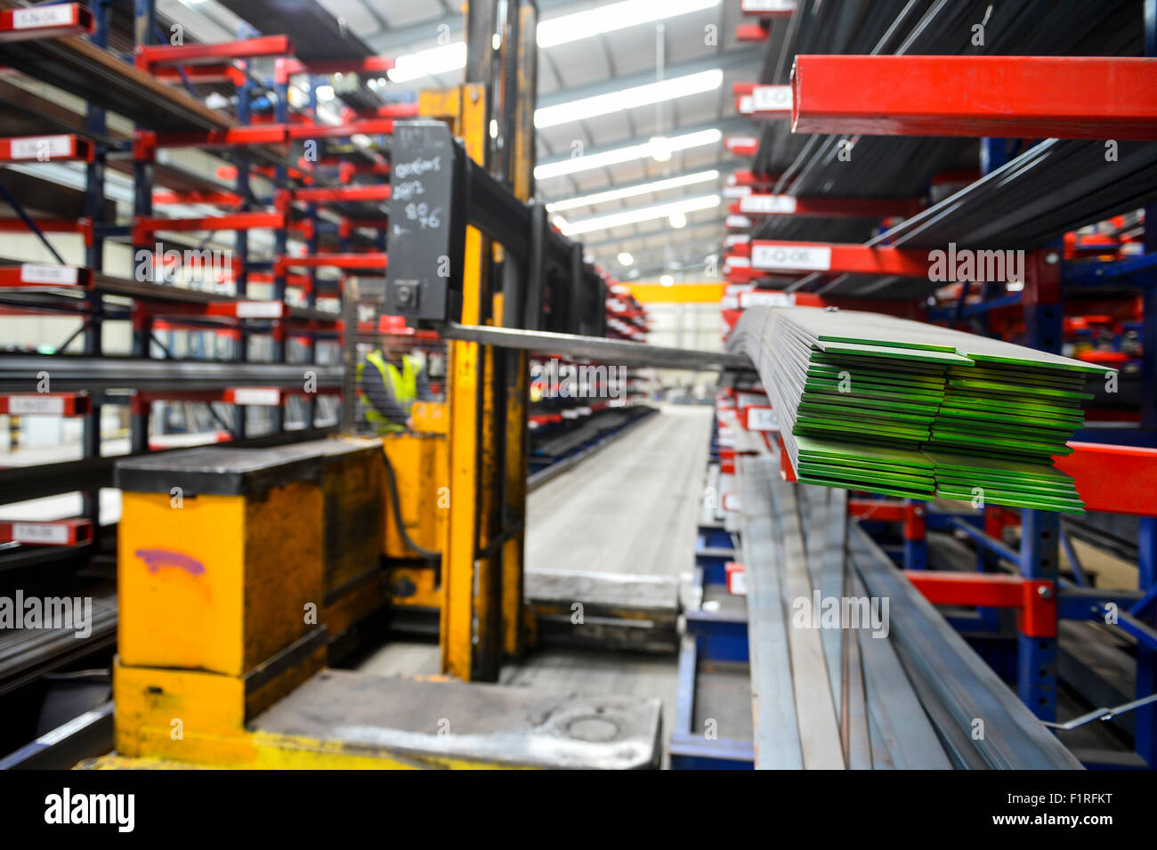 Steel warehouse racking side loading forklift Stock Photo - Alamy