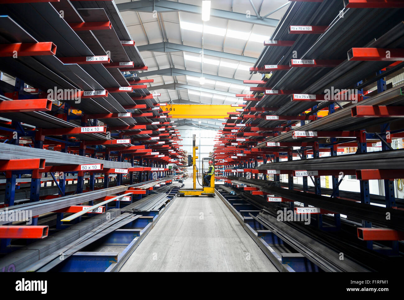 Steel warehouse racking side loading forklift Stock Photo - Alamy