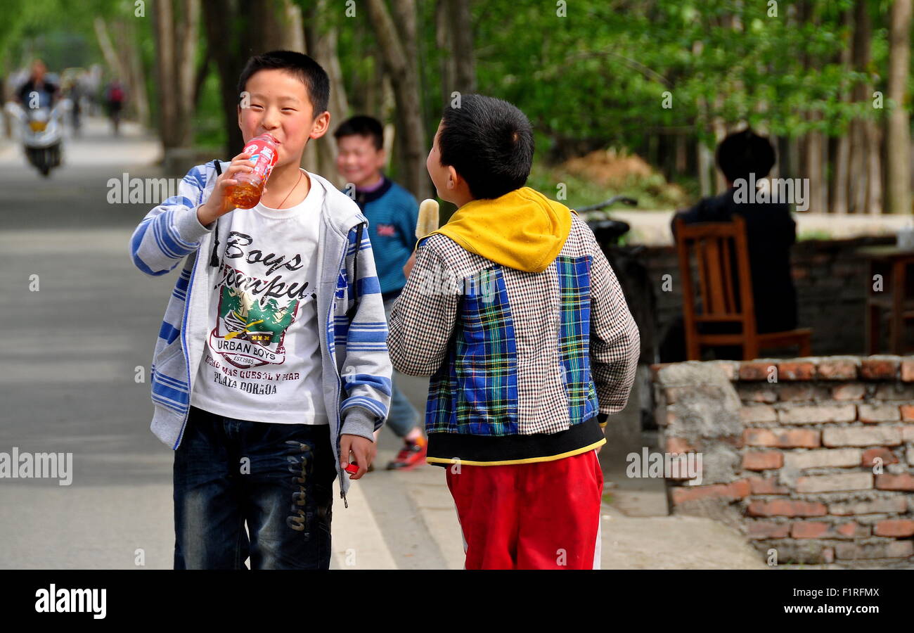 Pengzhou, China: Two Chinese boys eating ice cream and drinking bottled ...