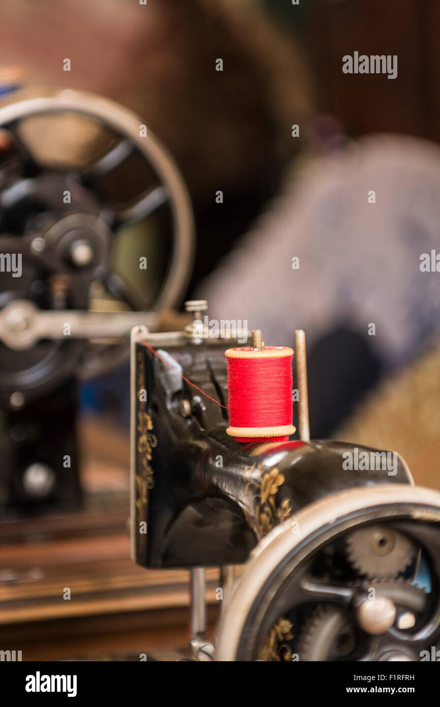 a spool of red threat being used on a circa 1860's sewing machine Stock ...